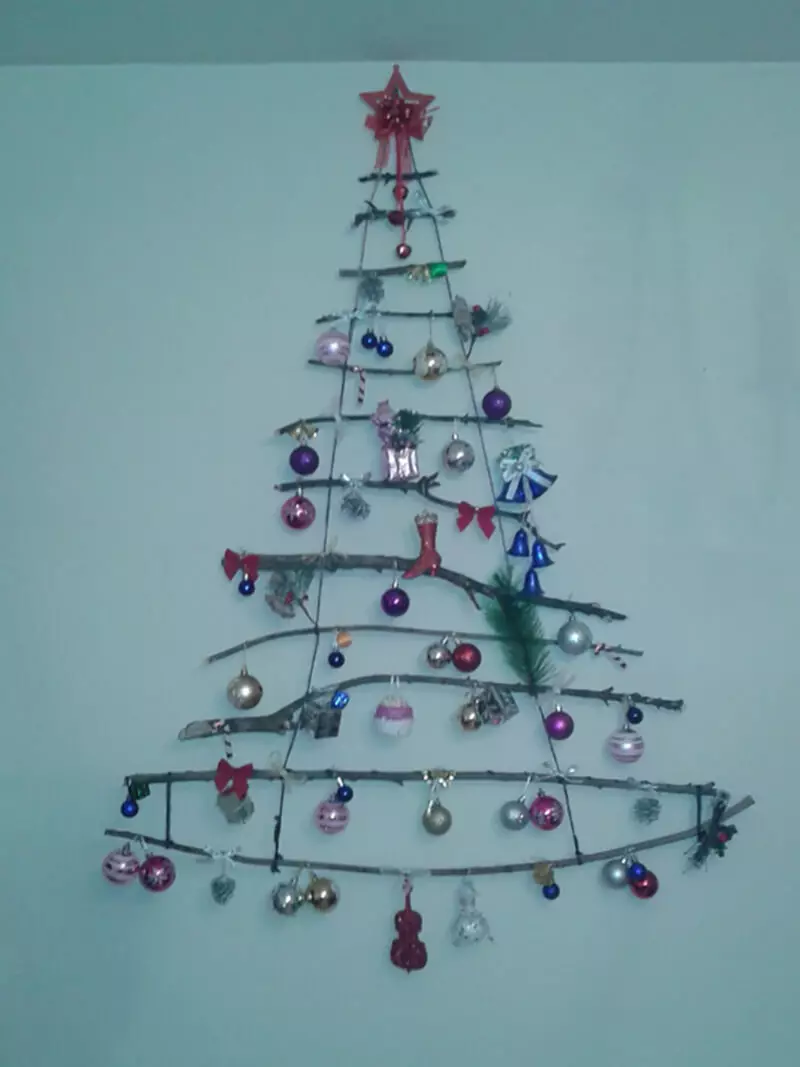 Árbol de navidad de las ramas. Árbol de ramas con sus manos.